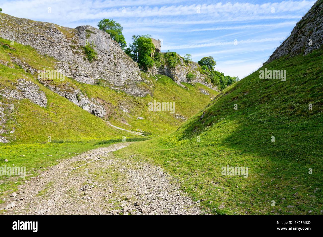 Wide footpath through Cave Dale turns right between vertical limestone ...