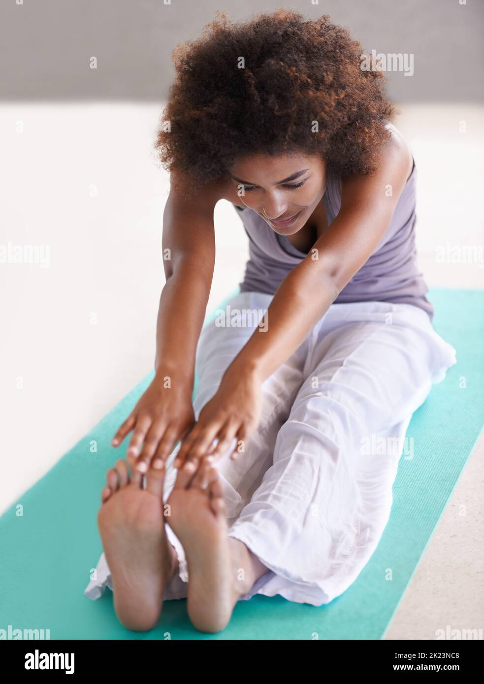 Its important to stretch properly. an attractive young woman stretching ...