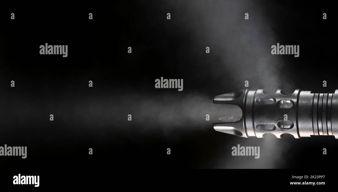 Gun barrel after firing with smoke on a black background with room for ...