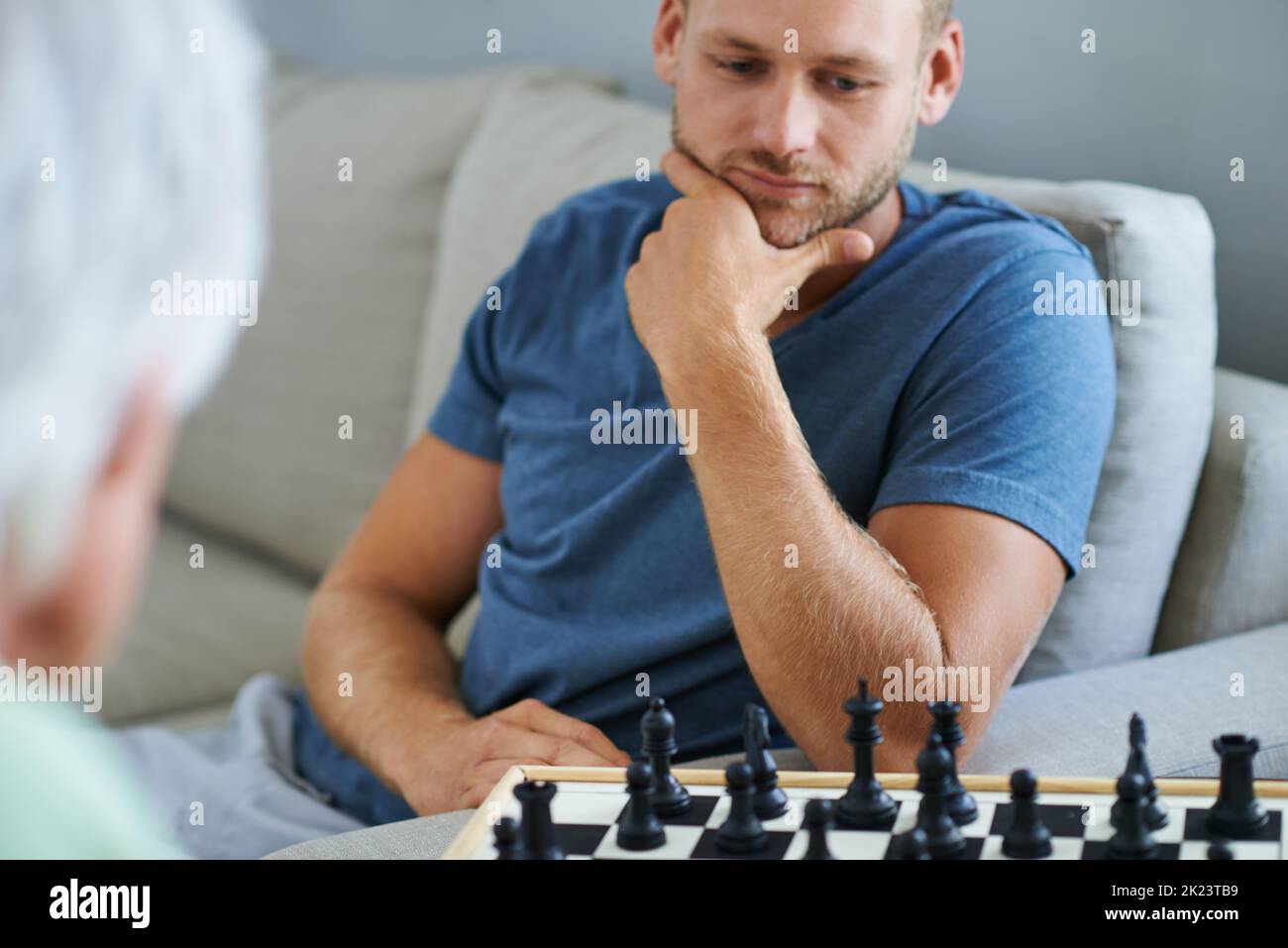 Planning his next move. a father and son playing a game of chess ...