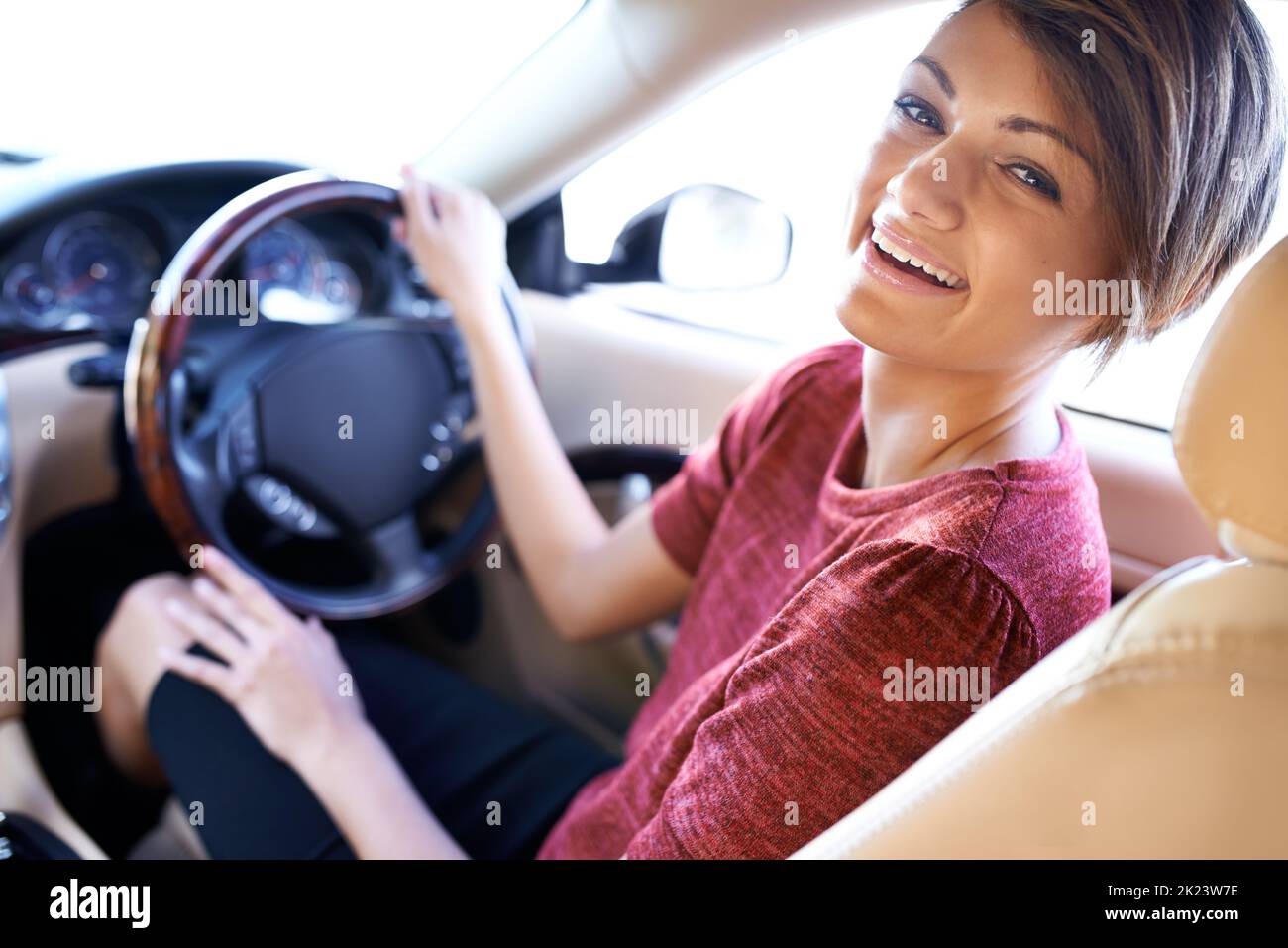 Lets take a roadtrip. a beautiful young woman driving a luxury car ...