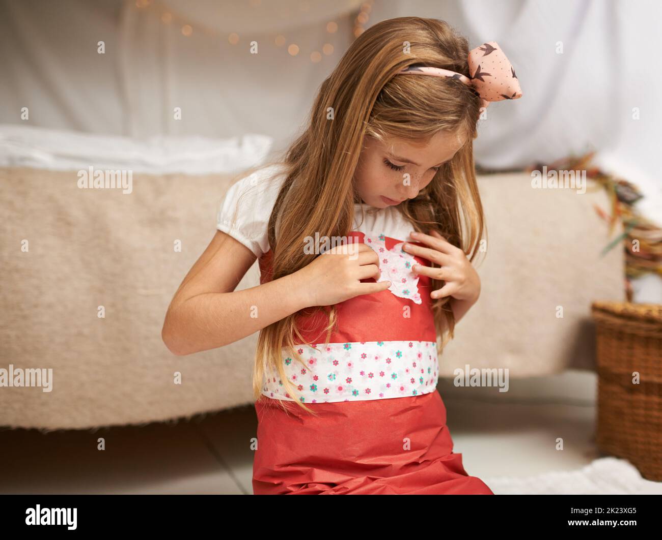 Decorating her dress. a cute little girl playing indoors Stock Photo ...