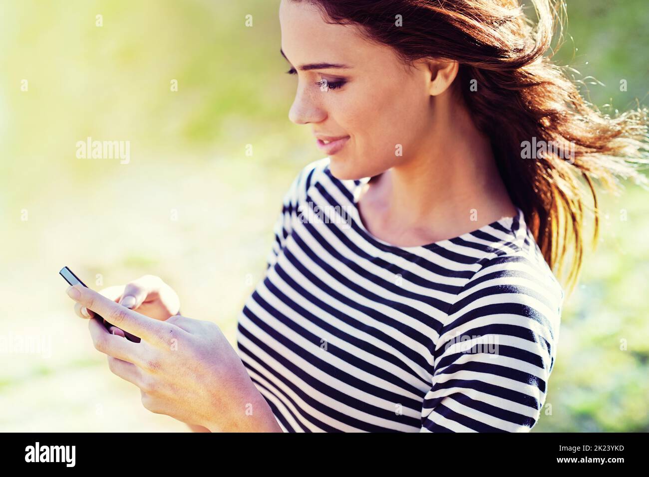 Waiting for his reply. a gorgeous young woman uisng her mobile phone ...