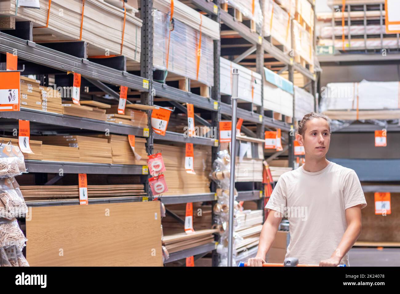 Young man excited looking to the side buying carrying a trolley and ...