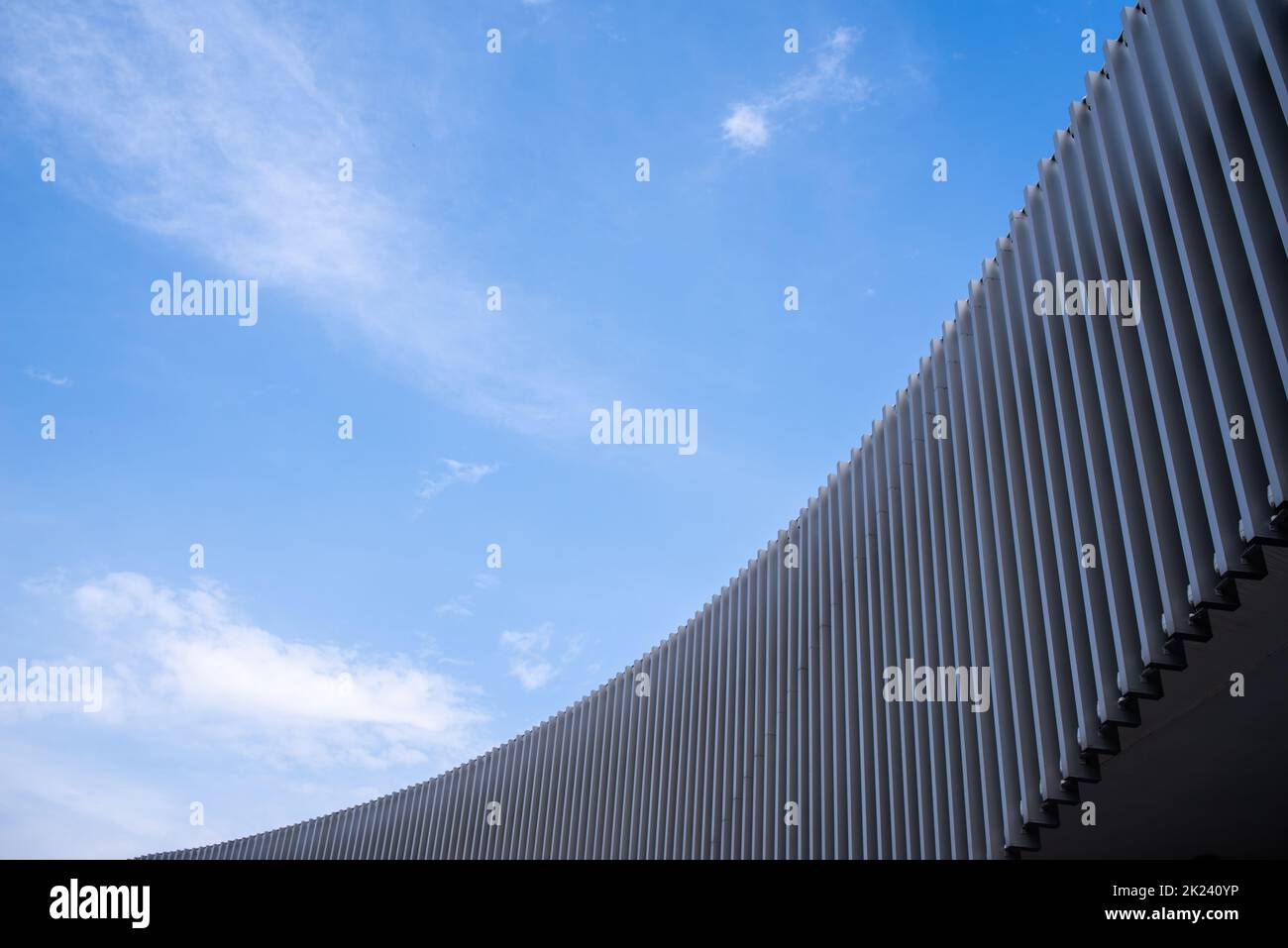 Corner of a modern steel building with geometric surface under the blue ...