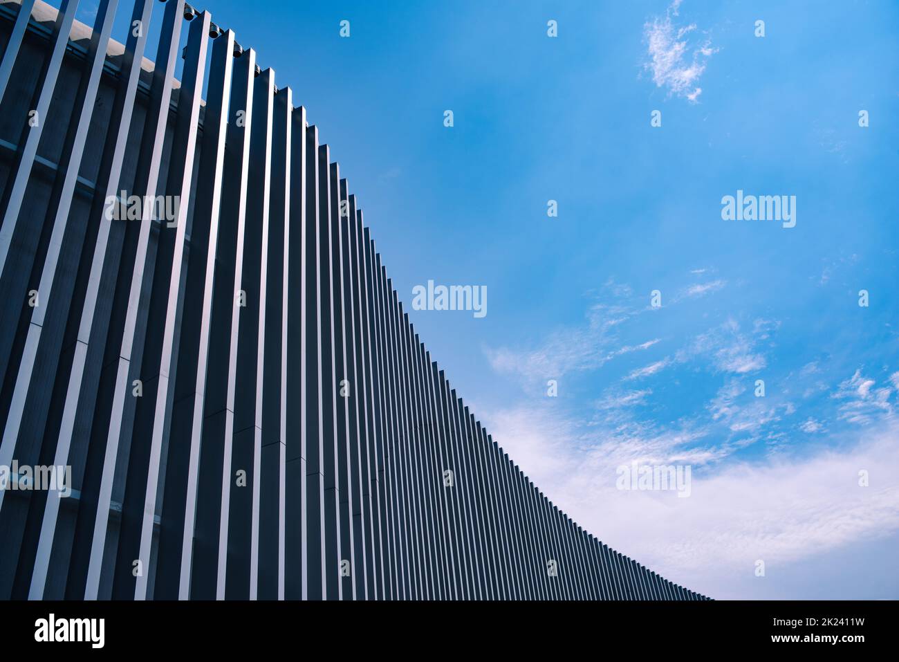 Corner of a modern steel building with geometric surface under the blue ...