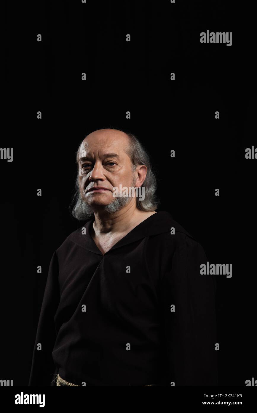 serious priest with grey hair and beard looking at camera isolated on ...