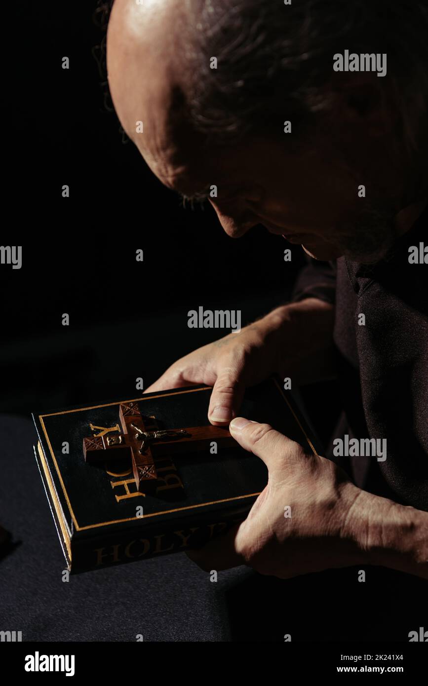 medieval monk holding holy cross and bible in darkness isolated on ...