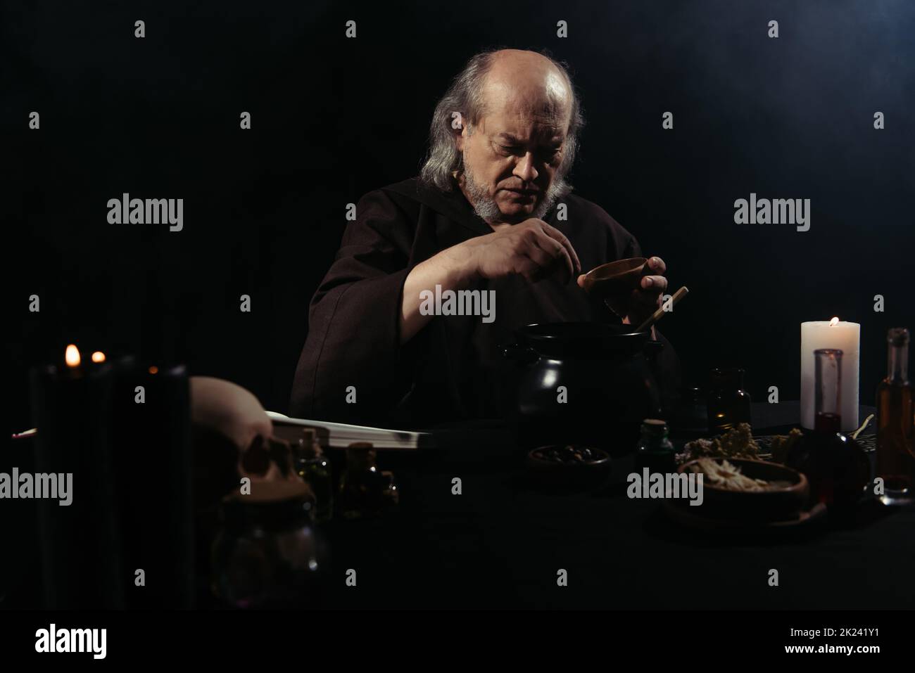 medieval alchemist preparing magic potion at night isolated on black ...