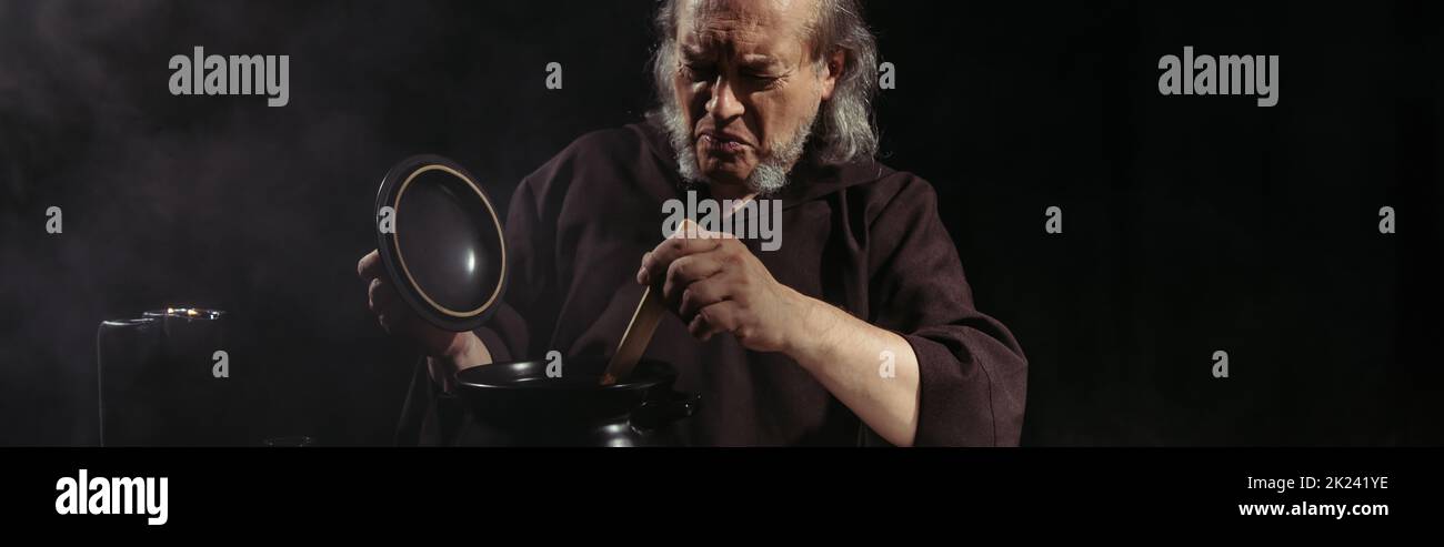 senior alchemist mixing potion in pot while cooking at night isolated ...