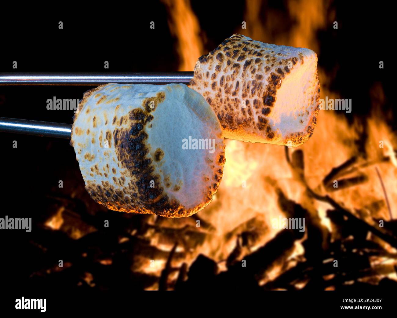 Two marshmallows being roasted over a campfire to make smores Stock ...
