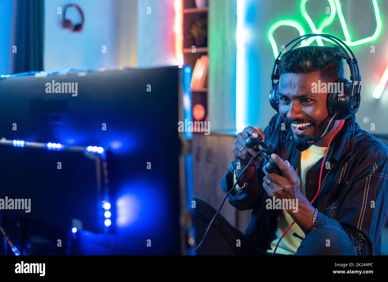 excited pro gamer playing online video game on computer by talking on ...