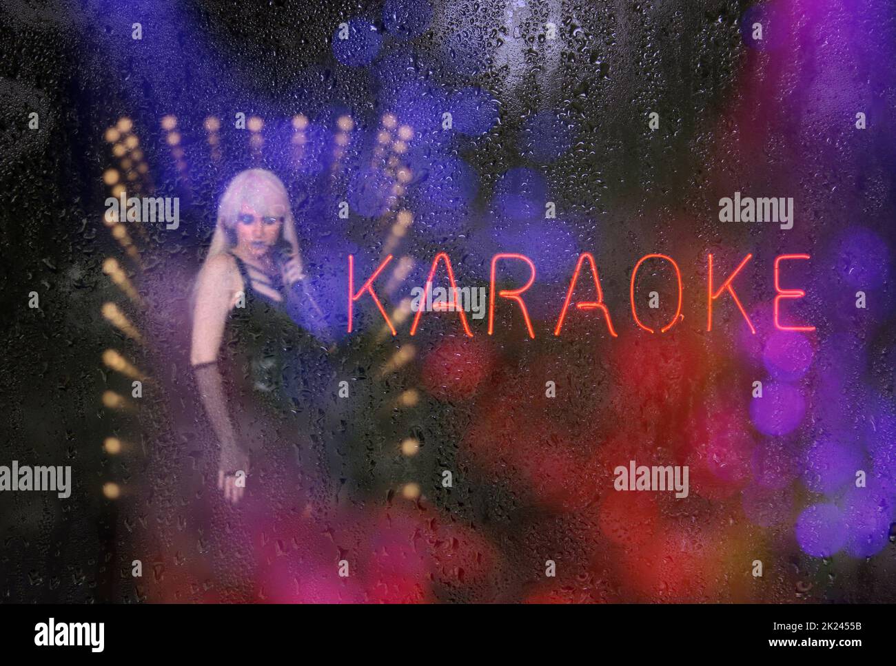 Neon Karaoke Sign with wet window and female singer, Focus on Sign ...