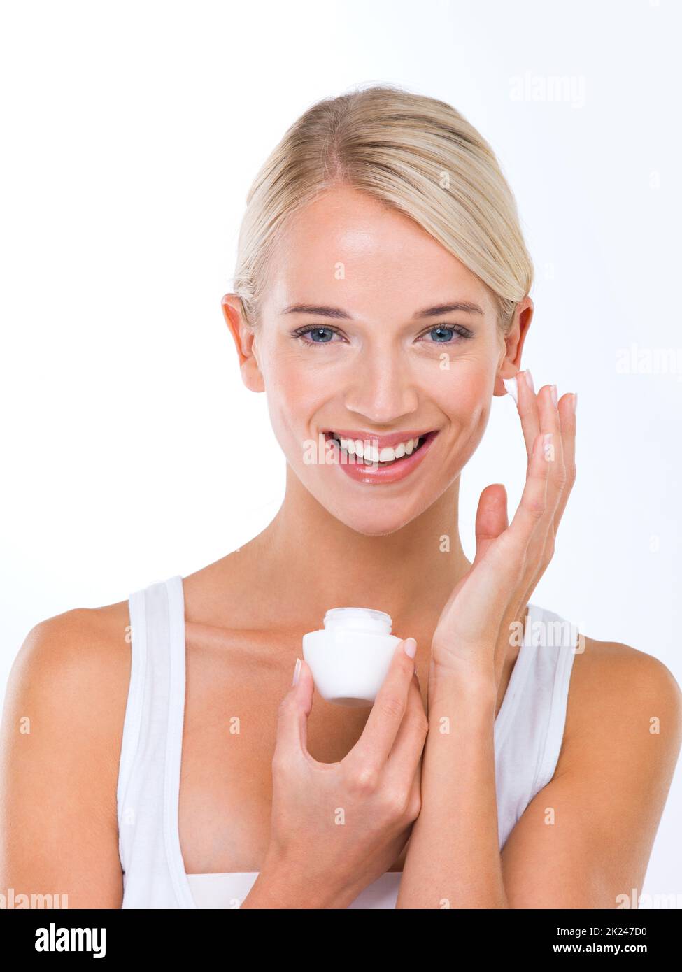 My favourite moisturiser. A beautiful young woman applying moisturiser ...