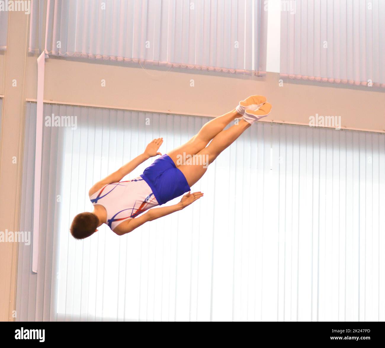 Young men are training in trampoline jumping, preparing for ...