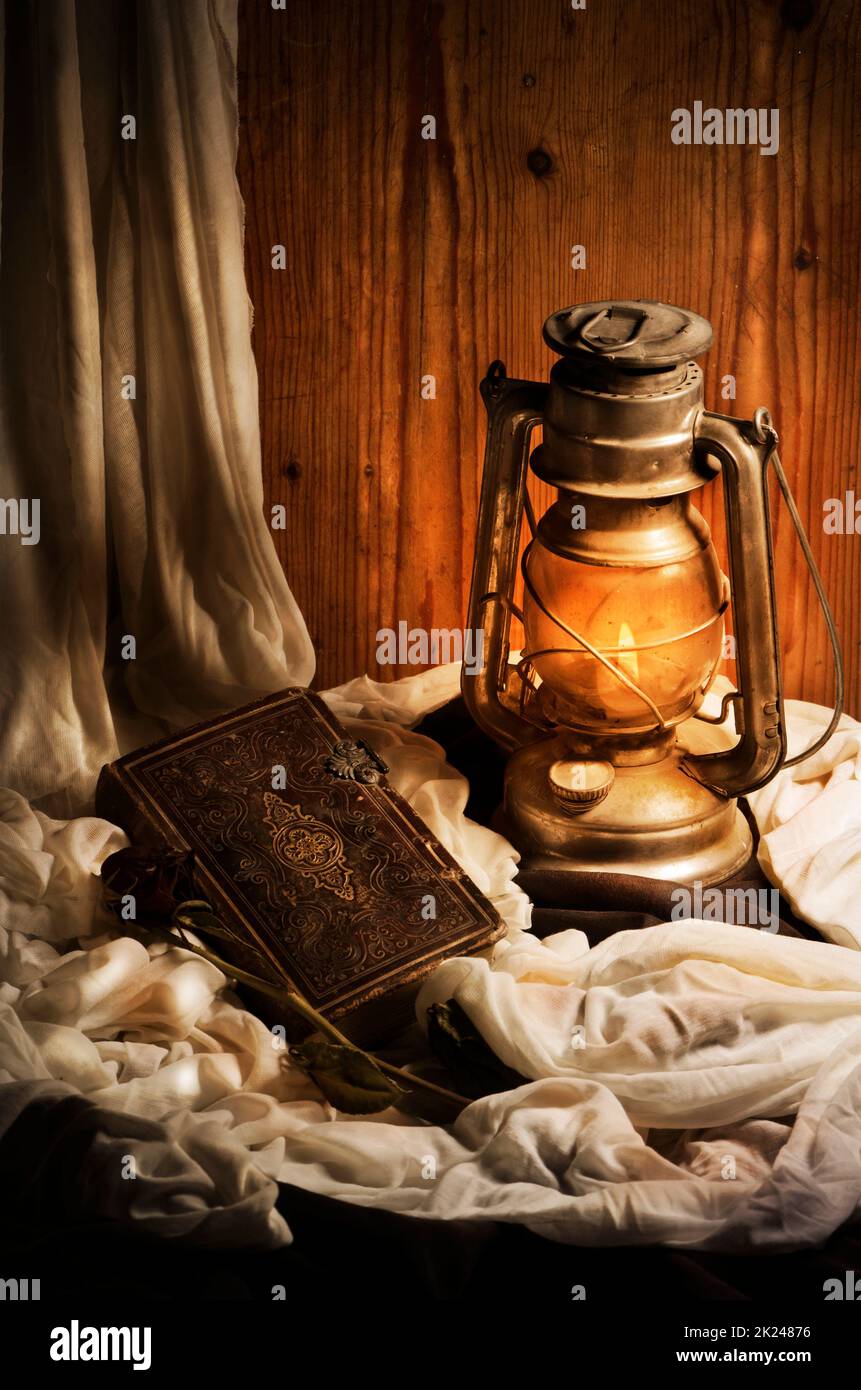 Still life. Lantern, old book and rose Stock Photo - Alamy