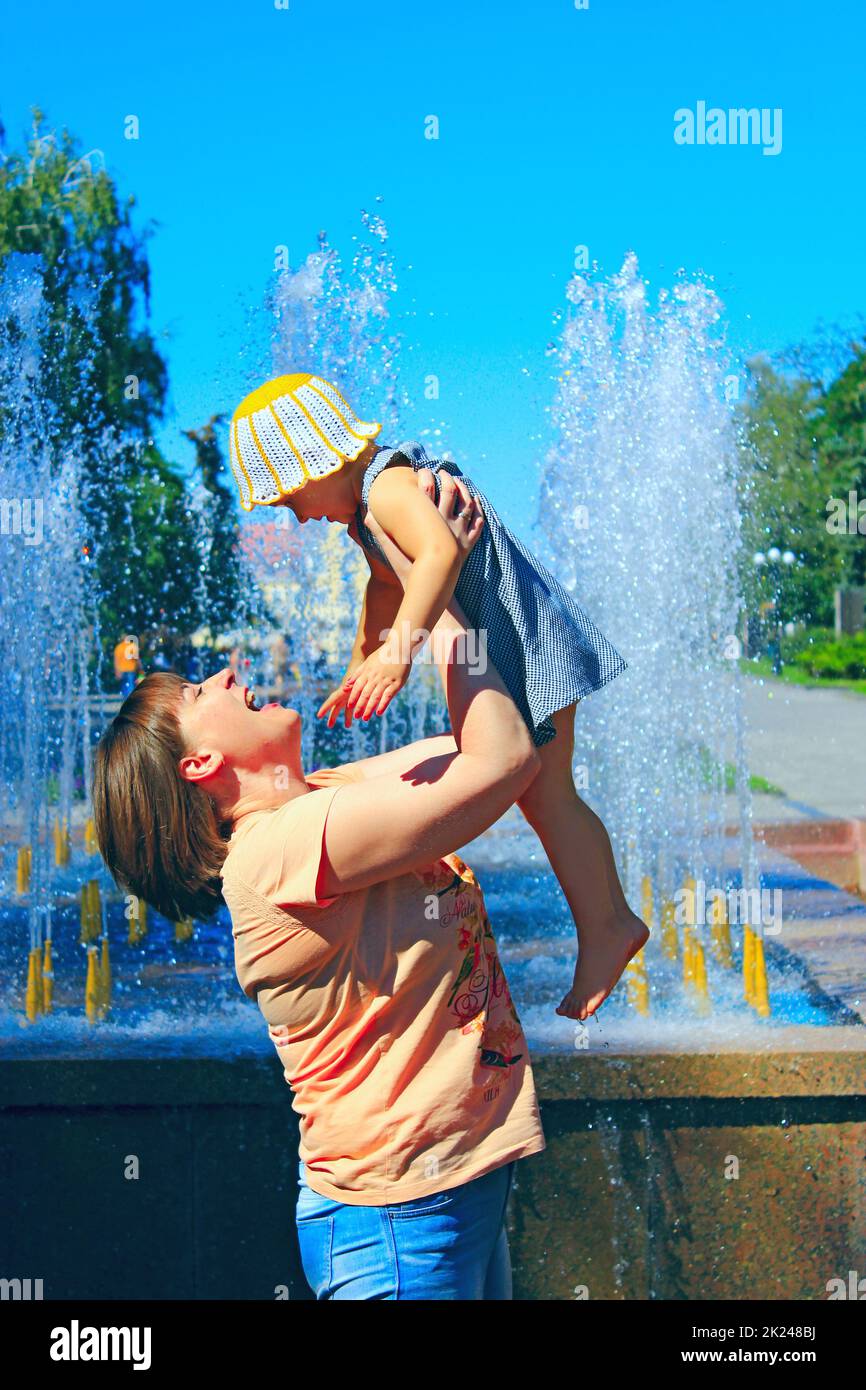 Happy mother throwing up childs. young adult woman playing with infant ...