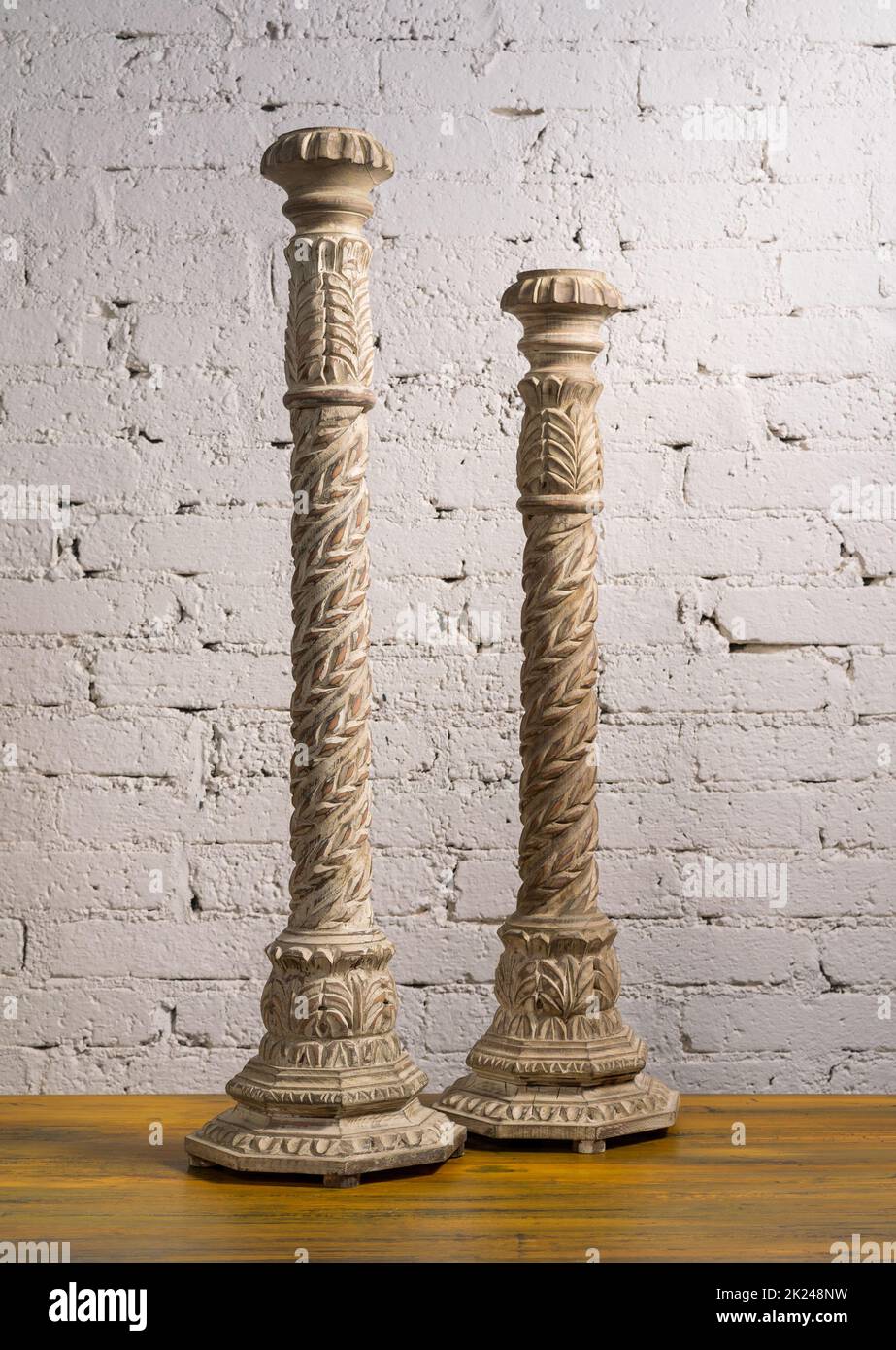 Two white vintage wooden candlesticks on a background of wooden floor ...