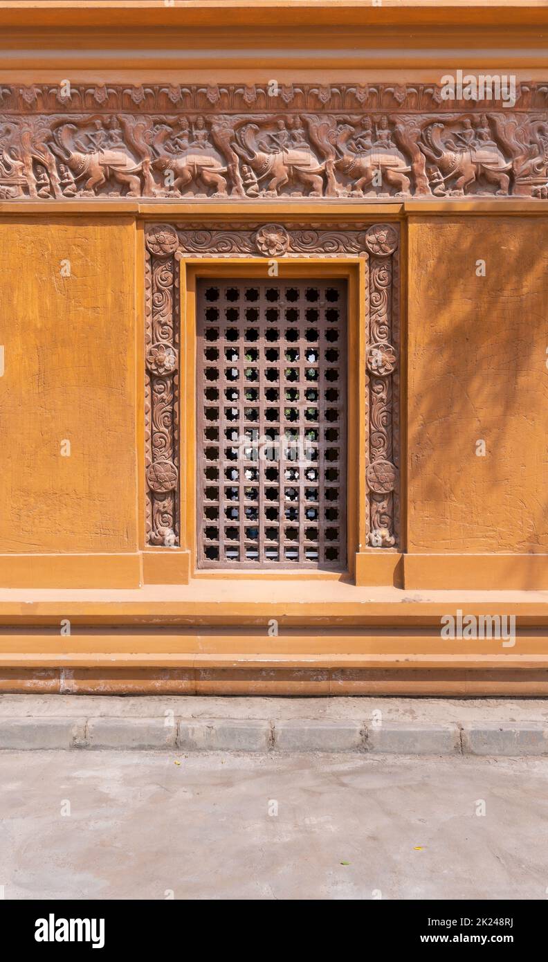 Wooden grid window installed in ornamental wall outside of old stone ...