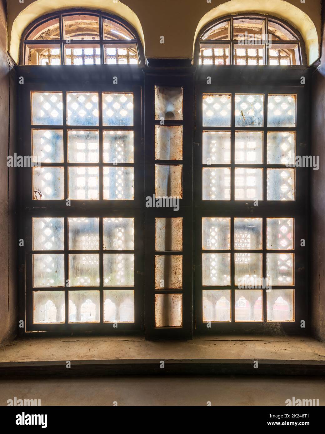 Large grunge vintage window with ornament located inside empty room ...