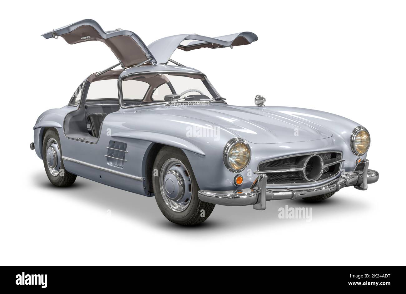 Silver colored historic vehicle with open gull-wing doors in white back ...