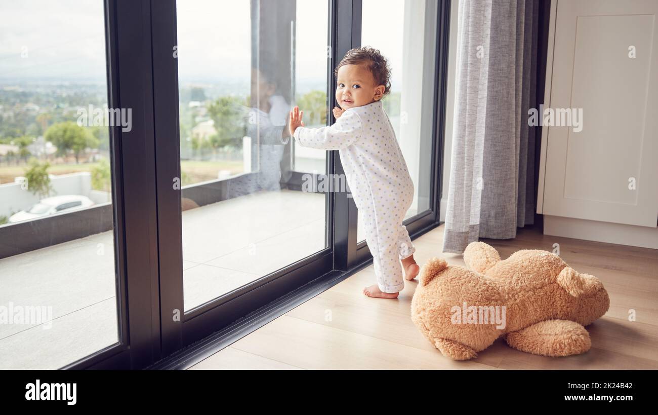 A baby by window, learning and walking for child development. Baby girl ... A baby by window, learning and walking for child development. Baby girl ...
