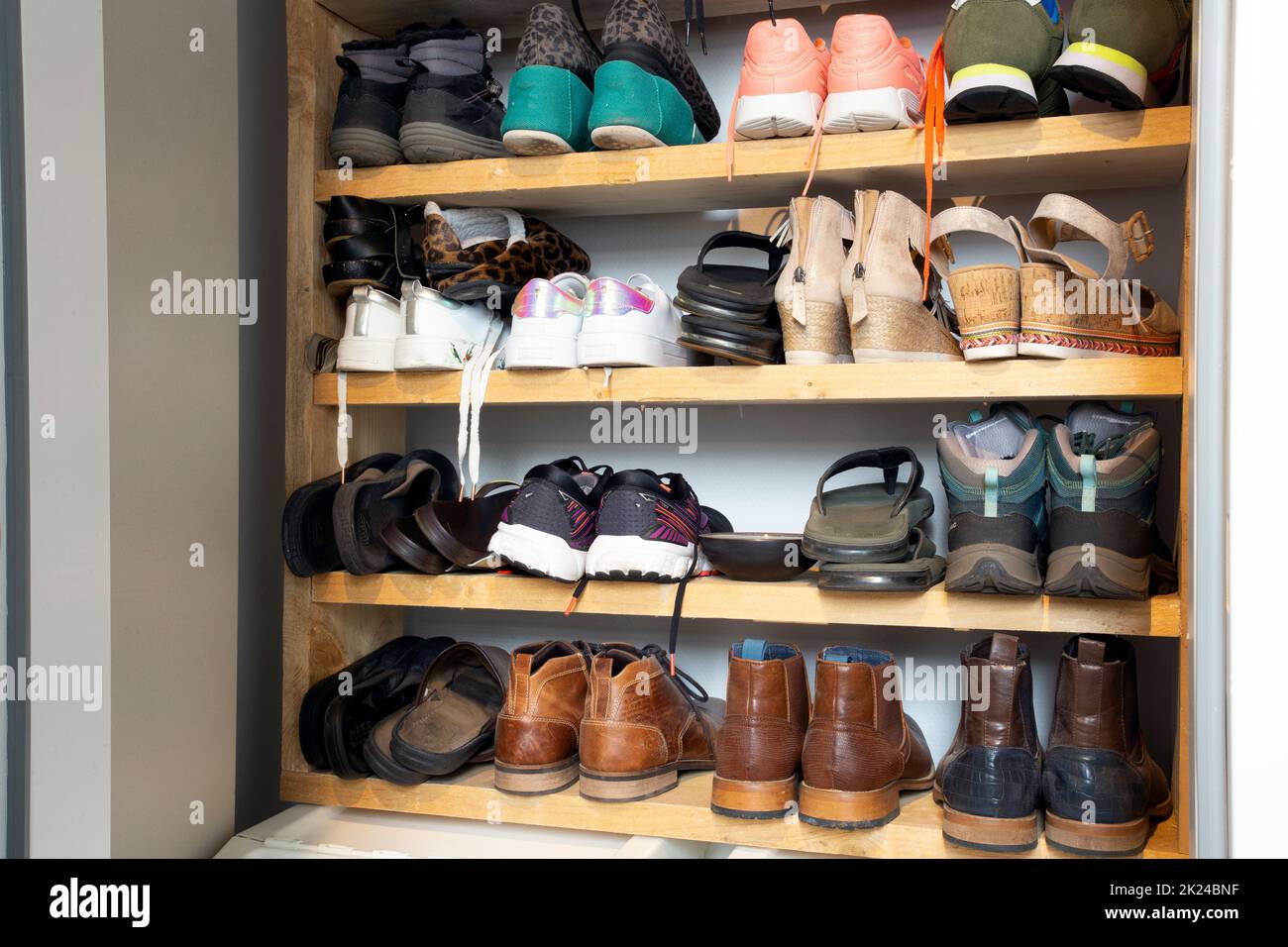 Collection of different shoes in shoe rack for storage, messy and needs ...