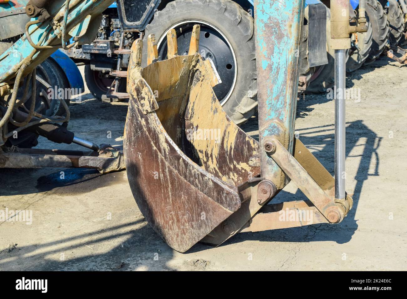 Tractor with a bucket for digging soil Stock Photo - Alamy