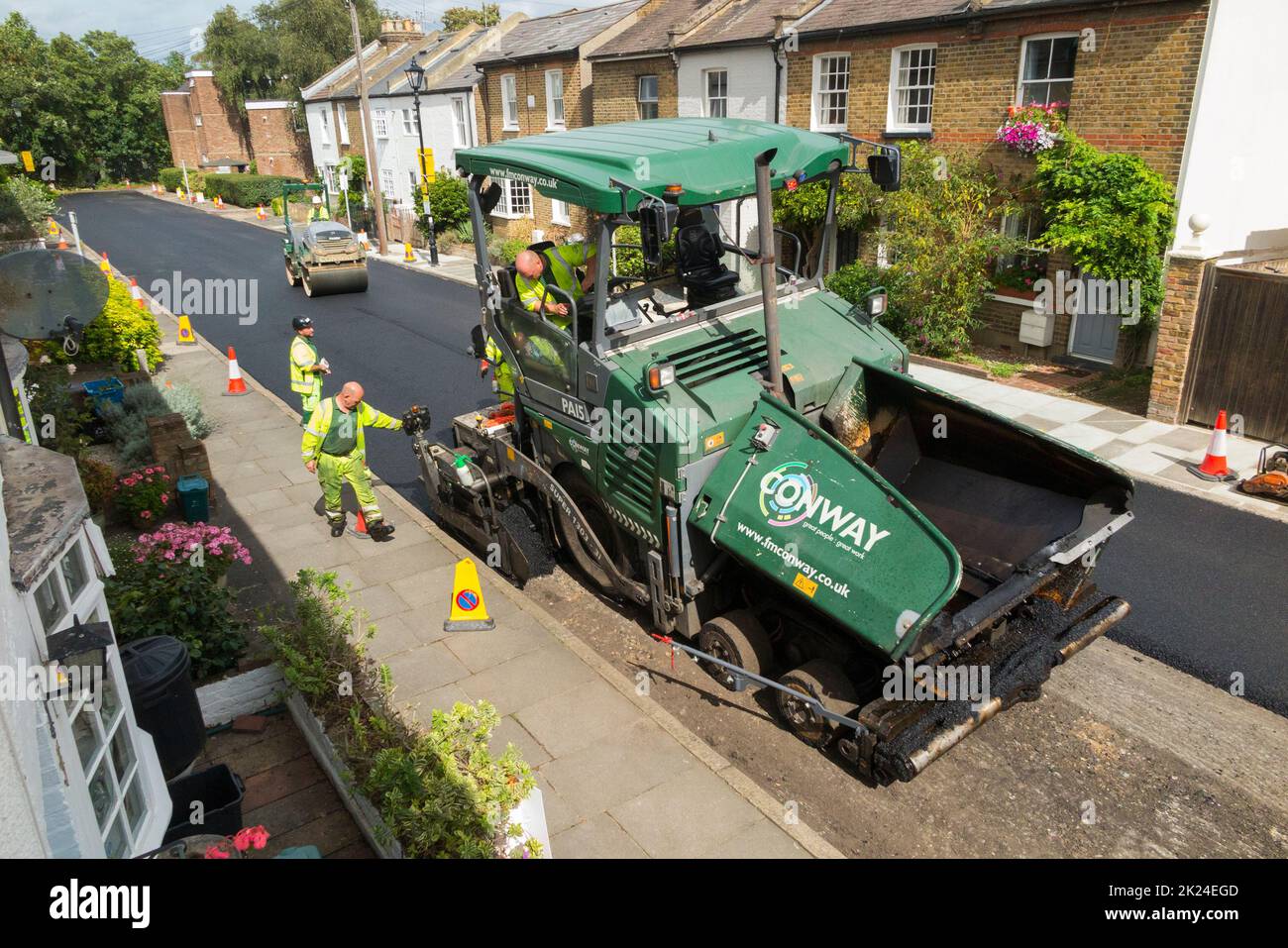 Hot tarmacadam being spread by an asphalt tarmac paver machine during ...
