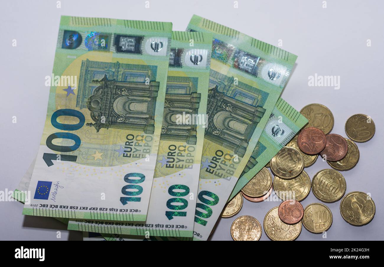 many 100 euro bills and coins on gray background detail view Stock Photo - Alamy