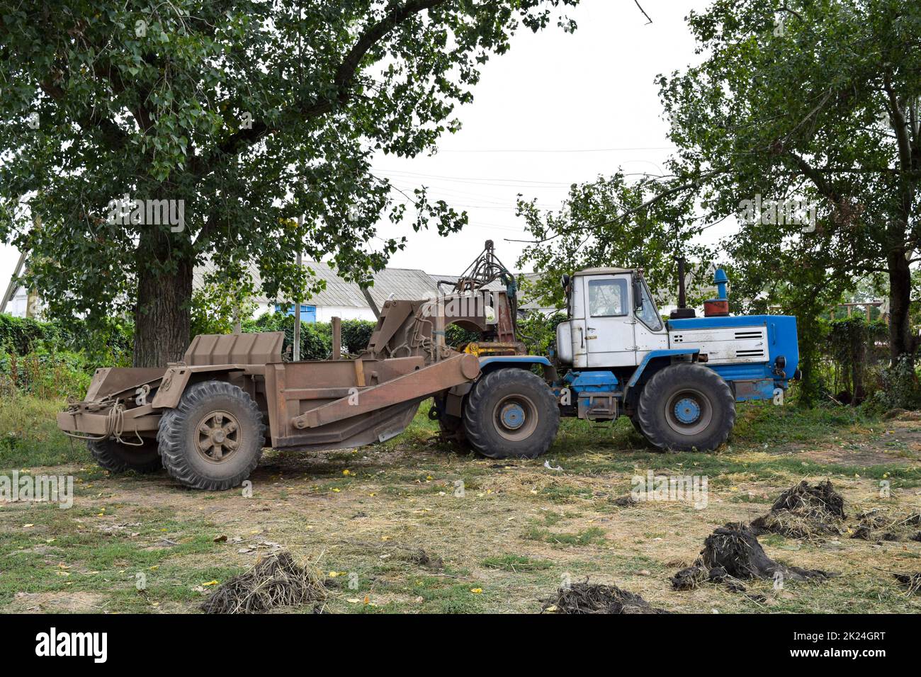 A large tractor with a grader on the trailer. Agricultural machinery ...