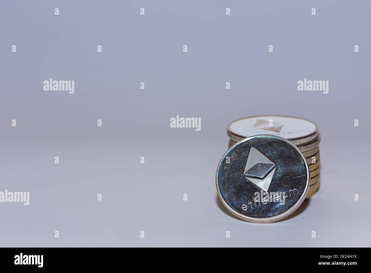stack of silver valueable ether coins from crypto currency with gray ...