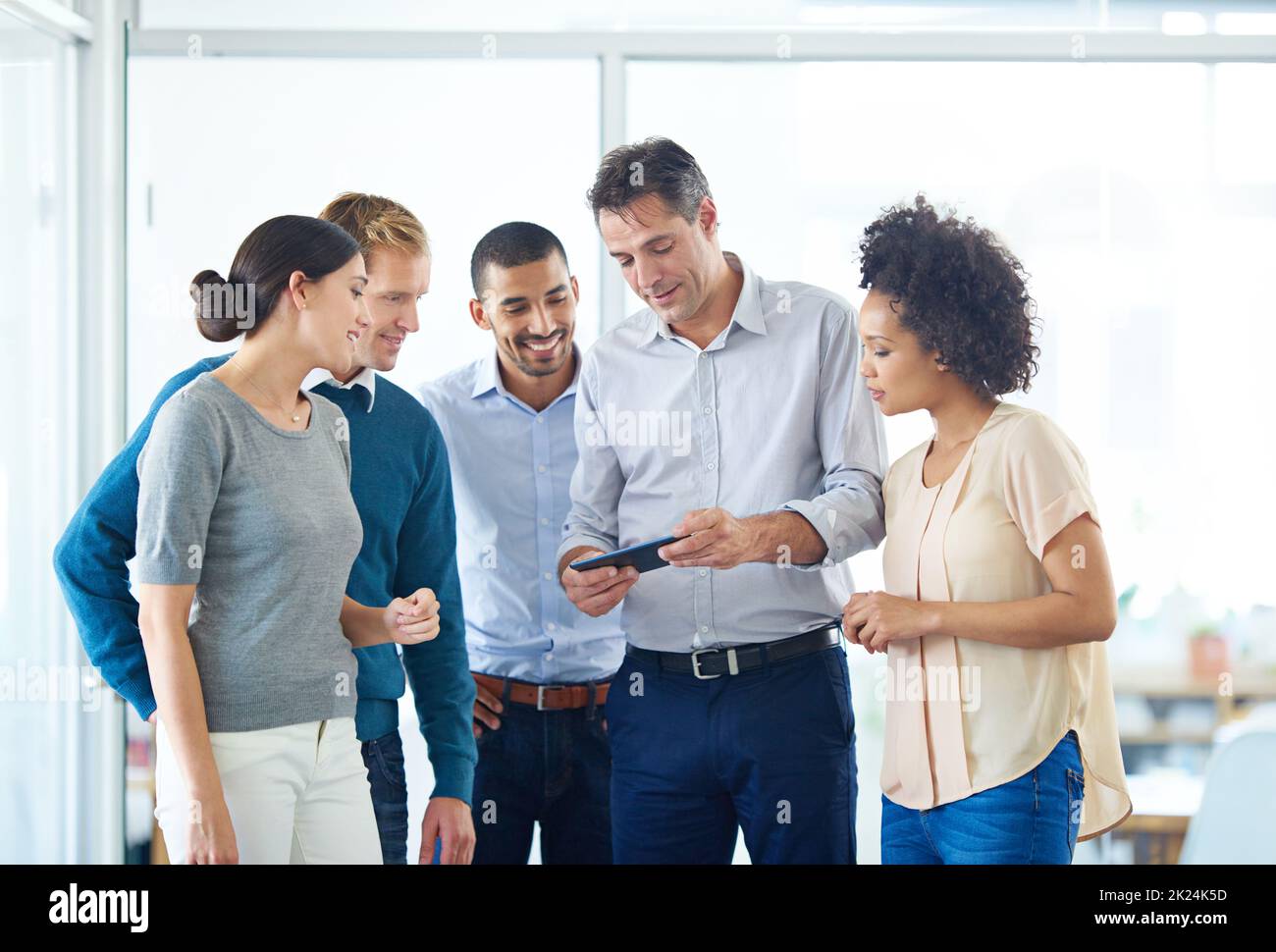 Technology is their new colleague. a group of colleagues using a ...