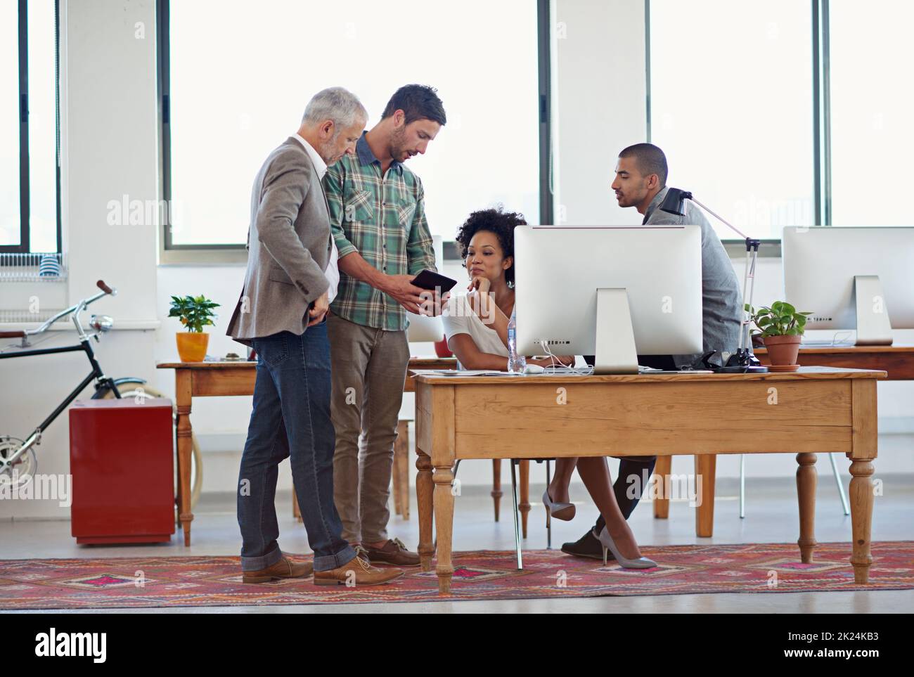 Tackling multiple platforms. A group of coworkers working together in ...