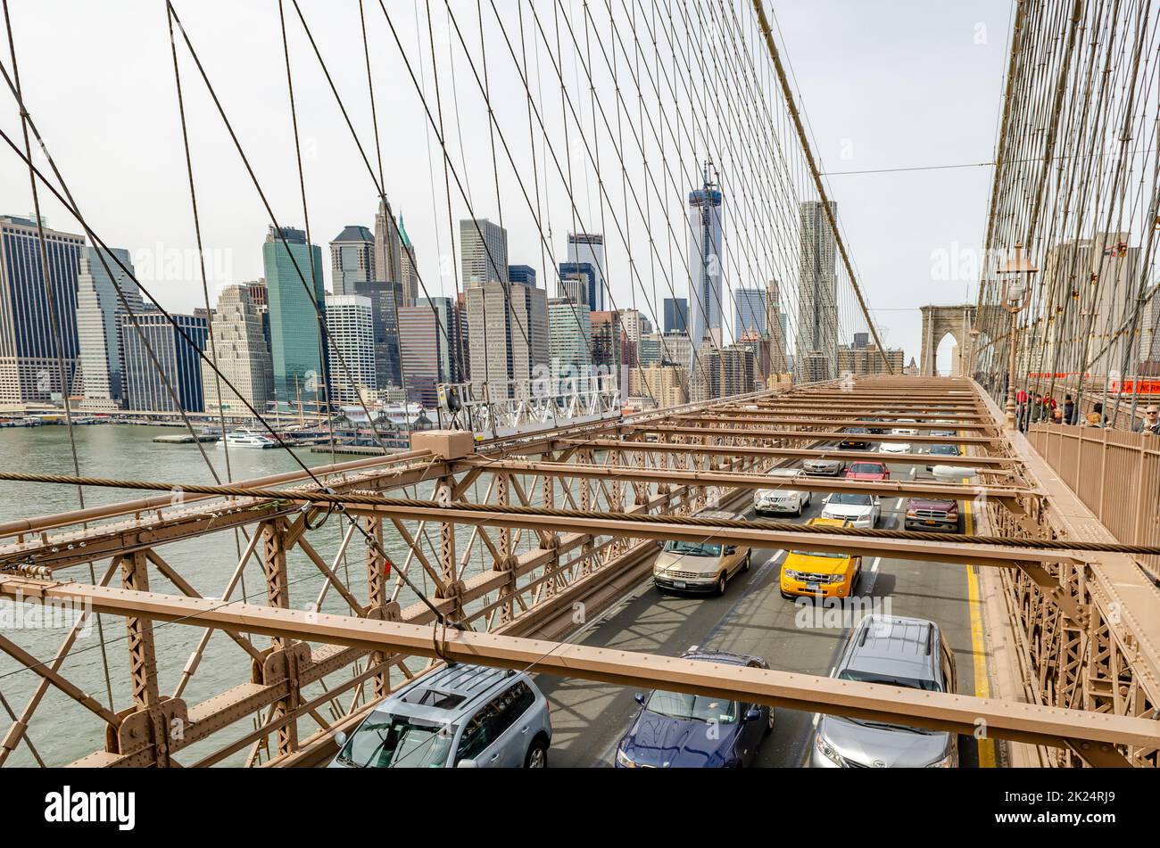 Different colored cars and taxi cab driving on Brooklyn Bridge New York ...