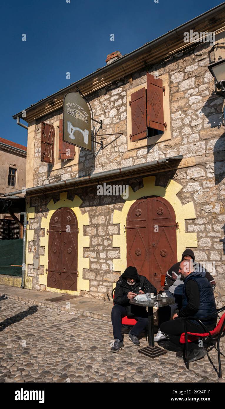 Mostar, Bosnia & Herzegovina, March 2022 - Men sitting outside an old ...
