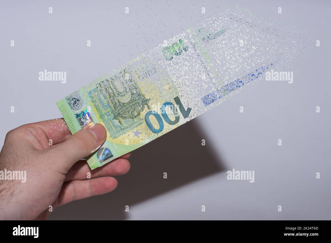 single euro bank note held in one hand decomposes and dissolves with ...