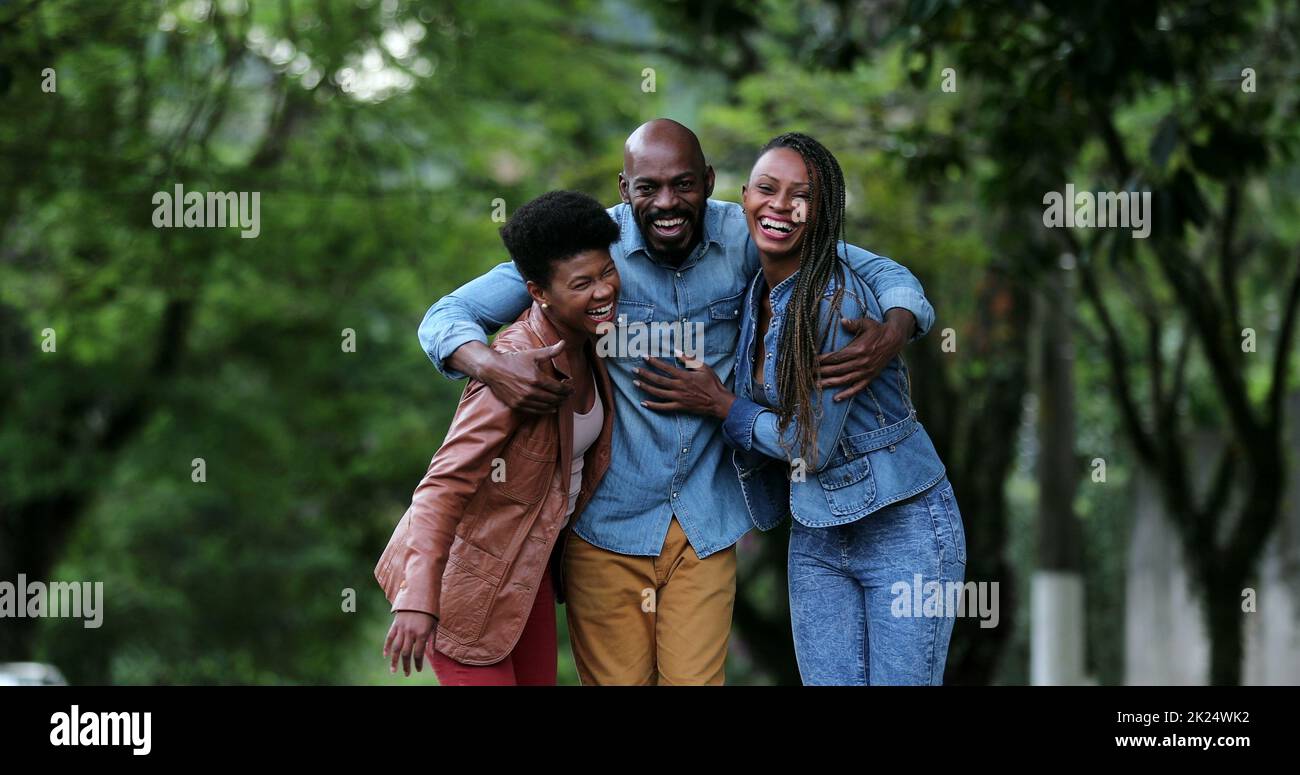Three happy people posing together. African ethnicity, friends smiling ...