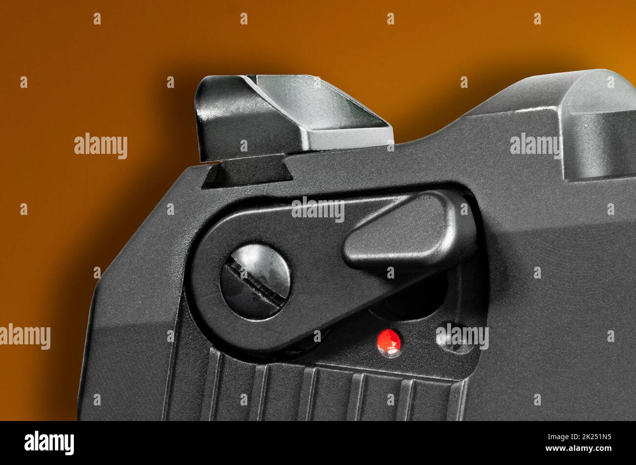 Safety off on a semi-auto pistol with a brown background and drop ...