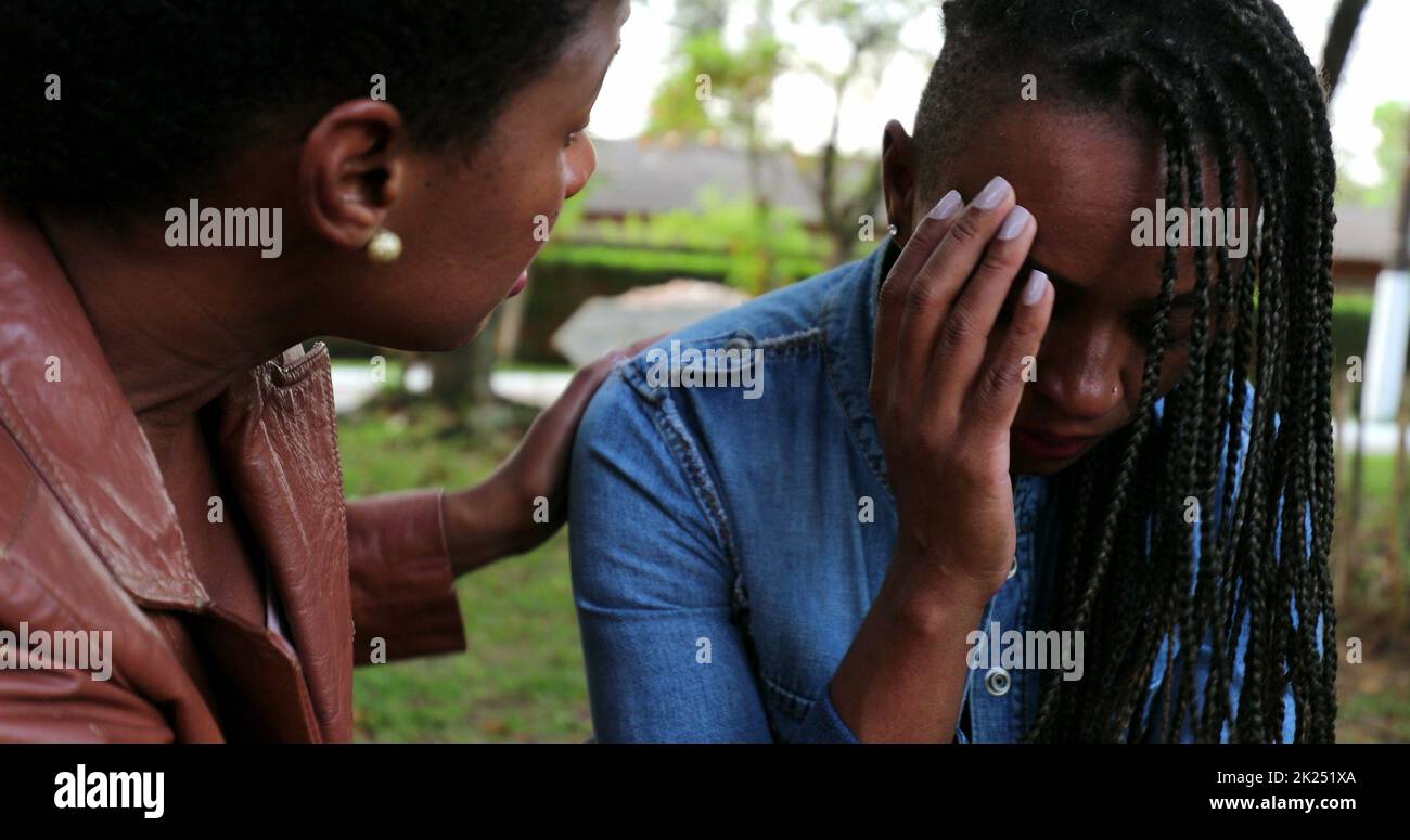 Friend helping depressed woman, black african ethnicity Stock Photo - Alamy