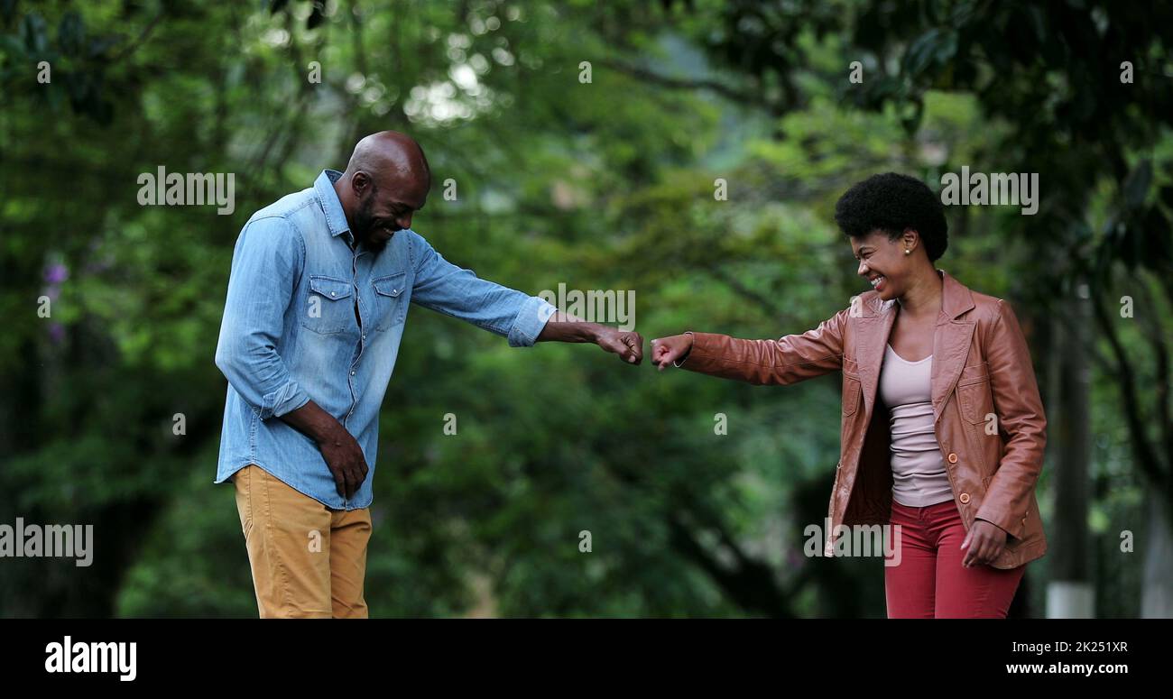 Friends doing fist bump, African man and woman bonding Stock Photo - Alamy