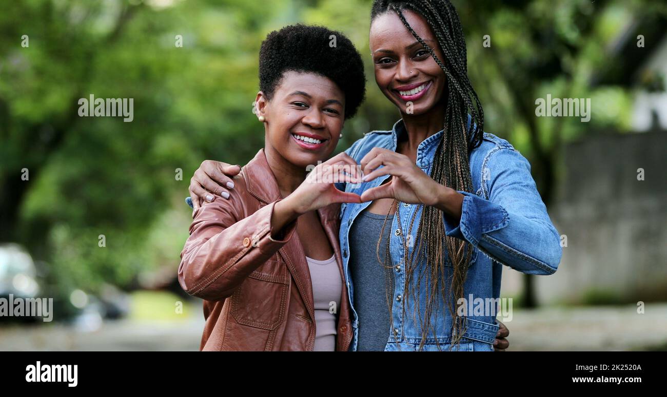 Friends making heart symbol together standing outside, african women ...