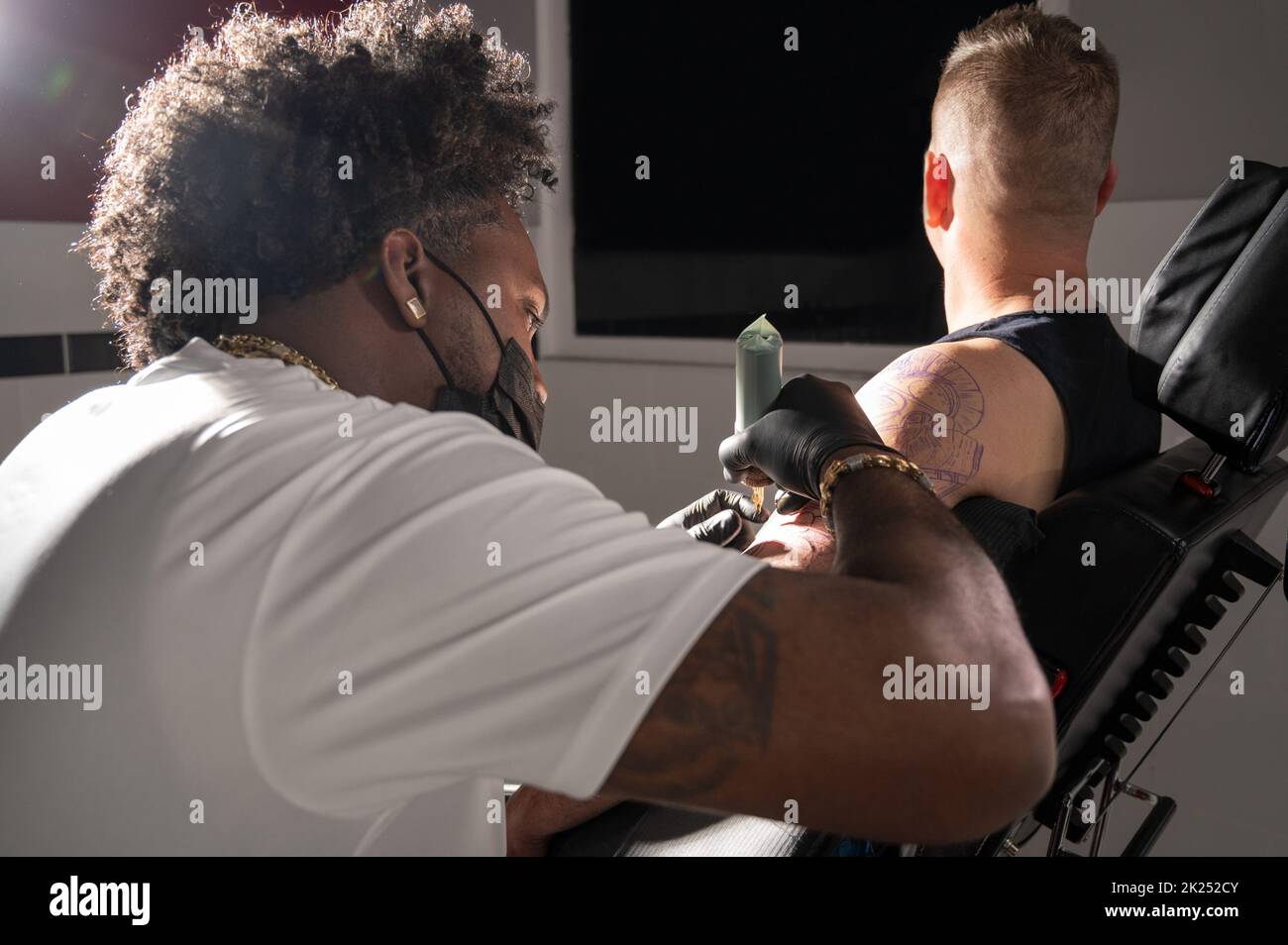 Cinematic shot of a Tattoo artist creating Body art at the tattoo ...
