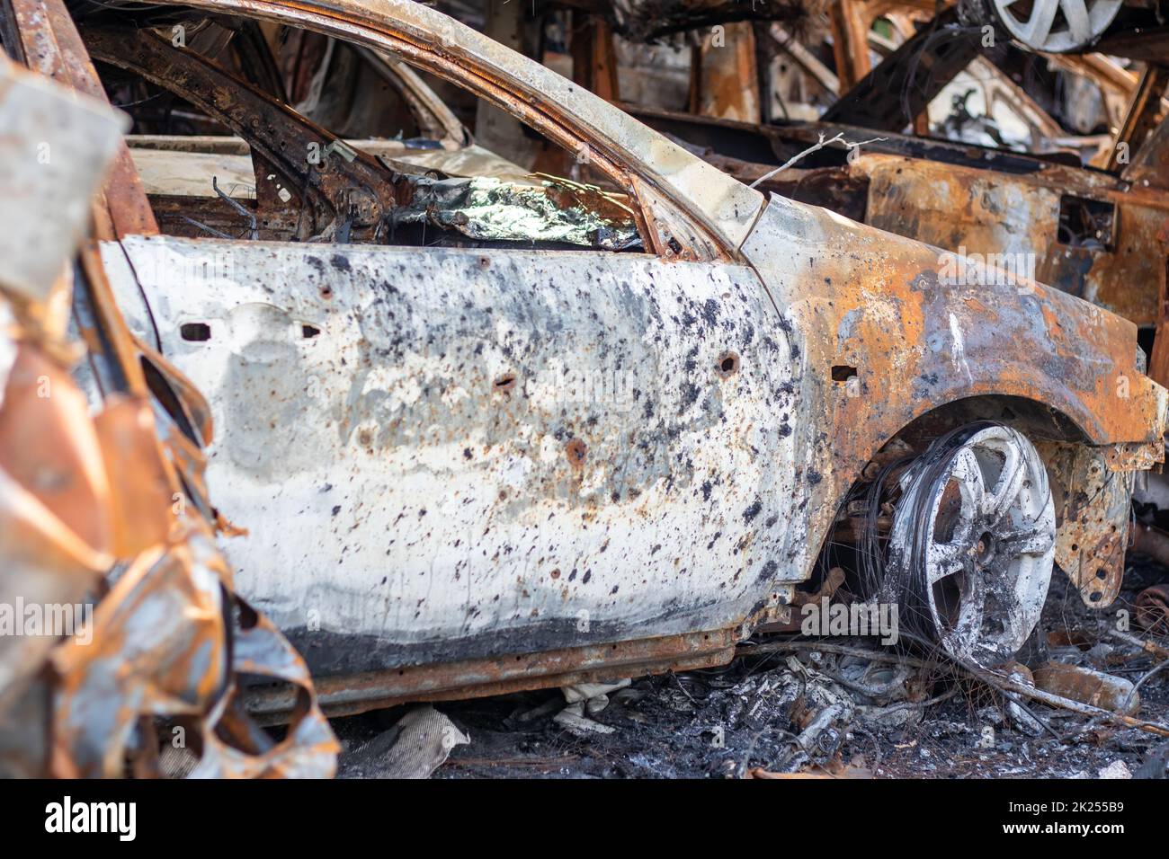 Burnt car body riddled with bullets. Russia's war against Ukraine. Shot ...