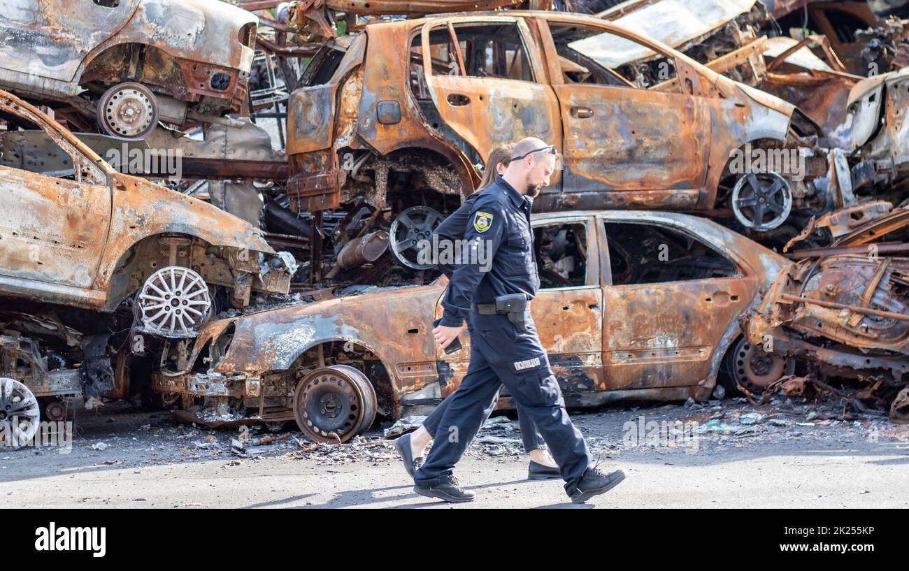 Police officers in front of burnt cars destroyed by rocket explosions ...