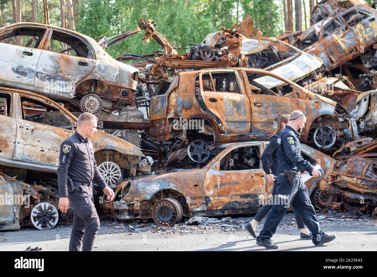 Police officers in front of burnt cars destroyed by rocket explosions ...