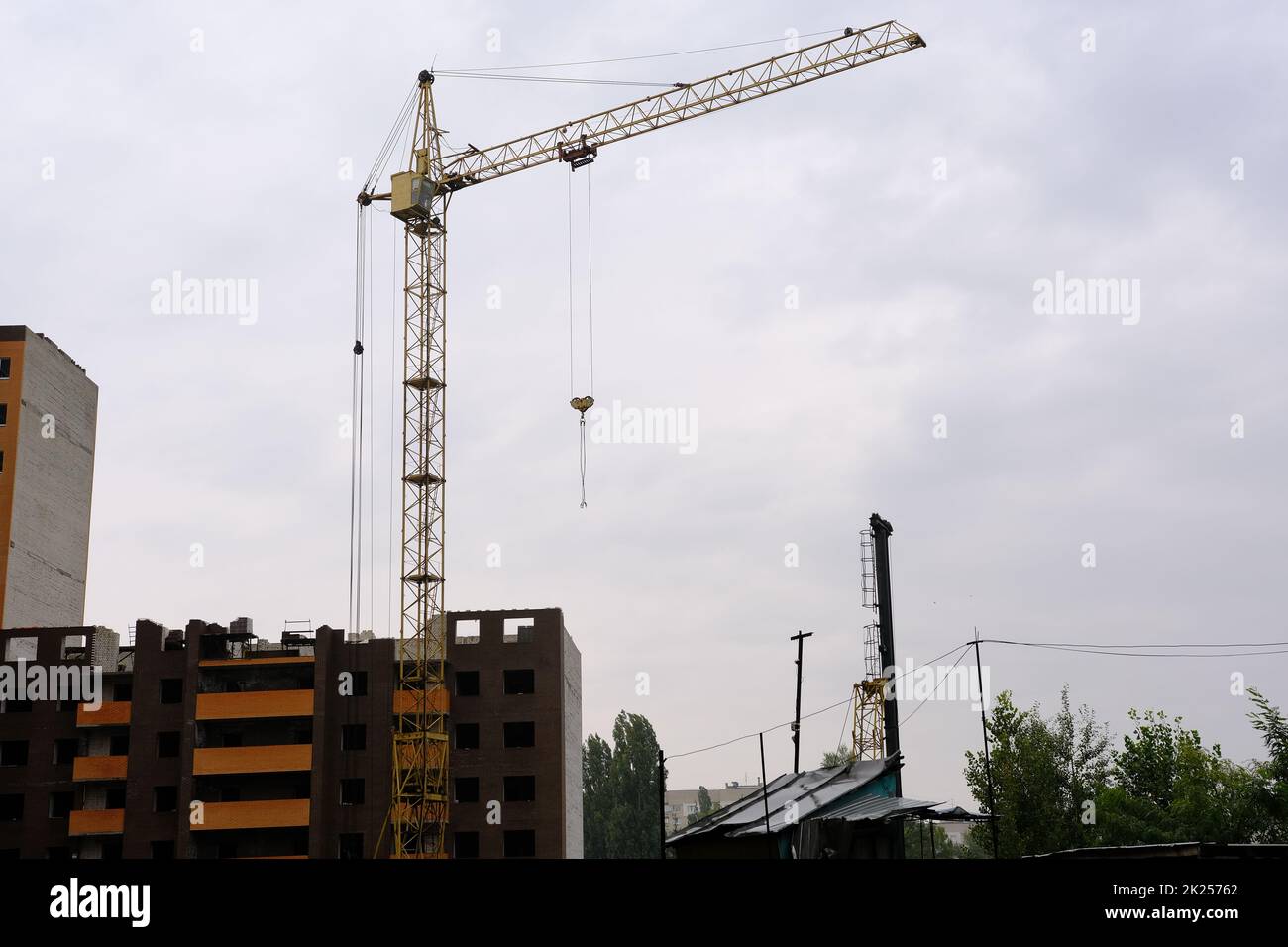 A crane builds a house at a height, lifts the load to the upper floor ...