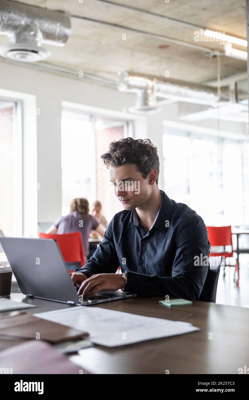 Graphic designer working hard at desk in coworking space Stock Photo ...