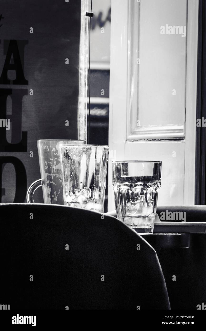 Empty glasses on a table backlit by a shuttered window Stock Photo - Alamy