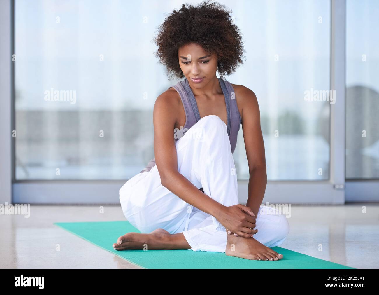 Shes got fitness on her mind. an attractive young woman doing stretches ...